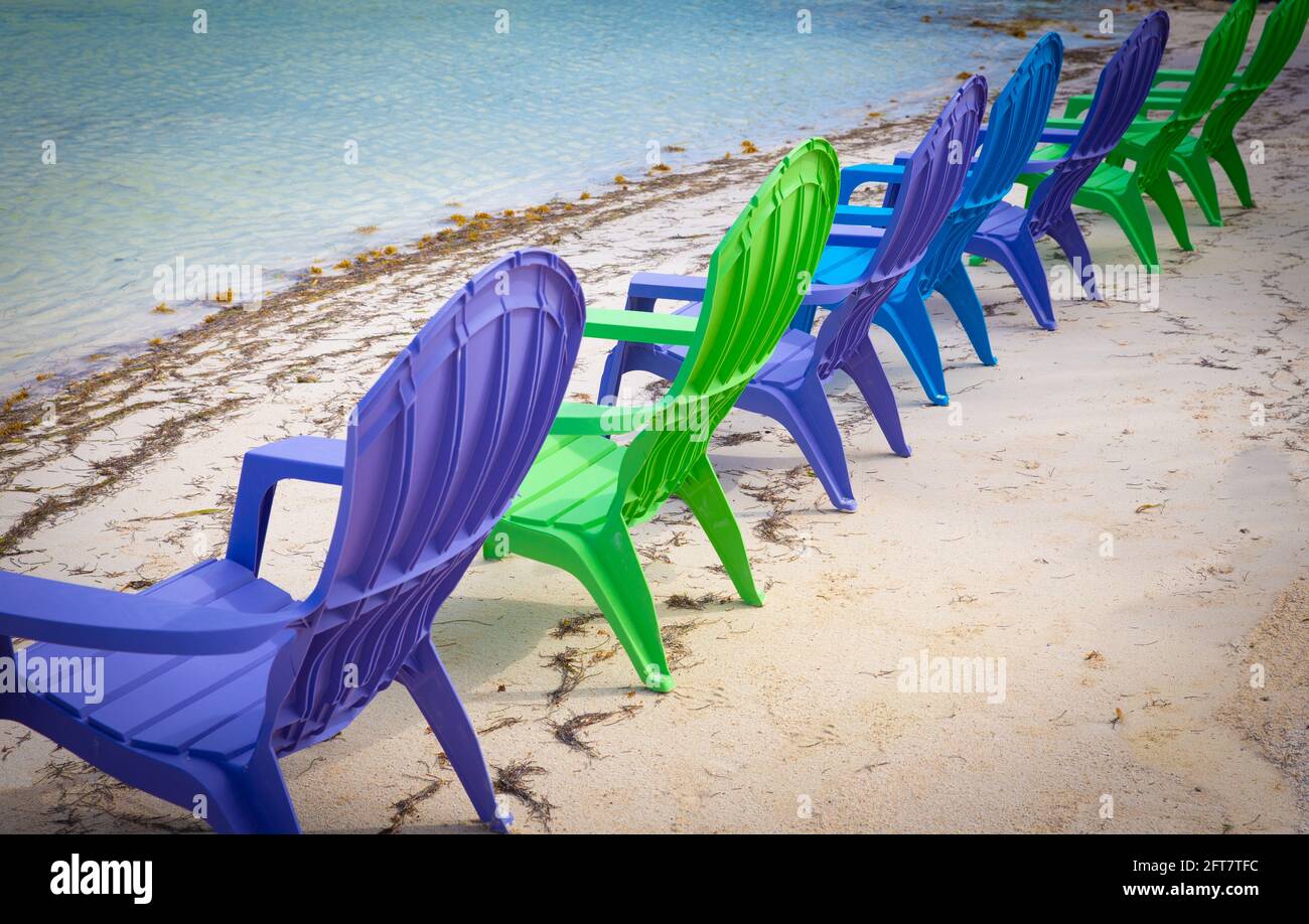 Colorful chairs on the beach for tourists to rest and have a drink ...