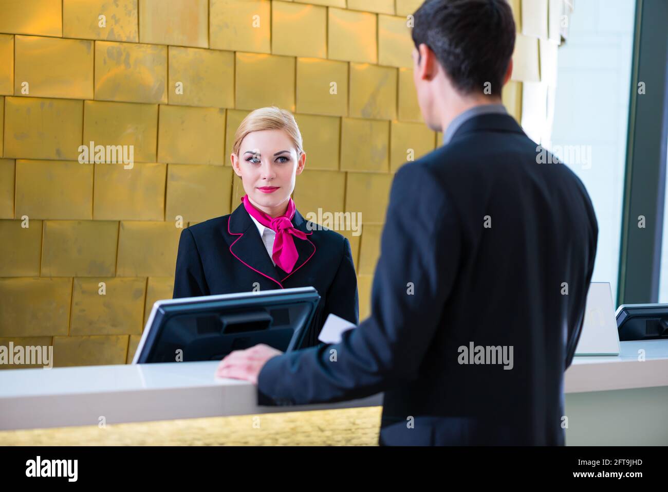 Man in Hotel check in at reception or front office being given key card ...