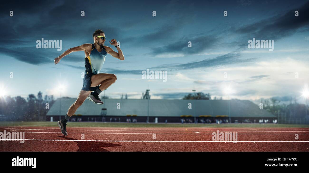 Professional male runner, jogger on stadium background. Caucasian fit ...