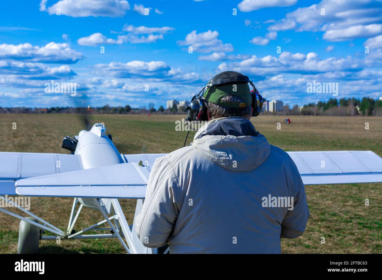 An operator with an unmanned airplane on the runway. A man is flying an ...