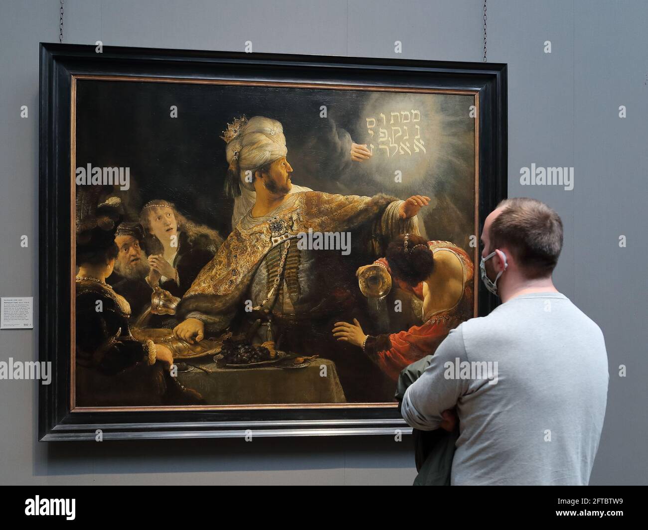 A man studying the painting Belshazzar's Feast by Flemish Baroque ...