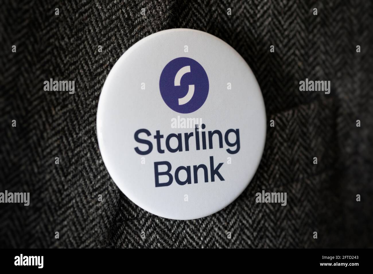 A button badge bearing the logo of Starling Bank fastened to a suit ...