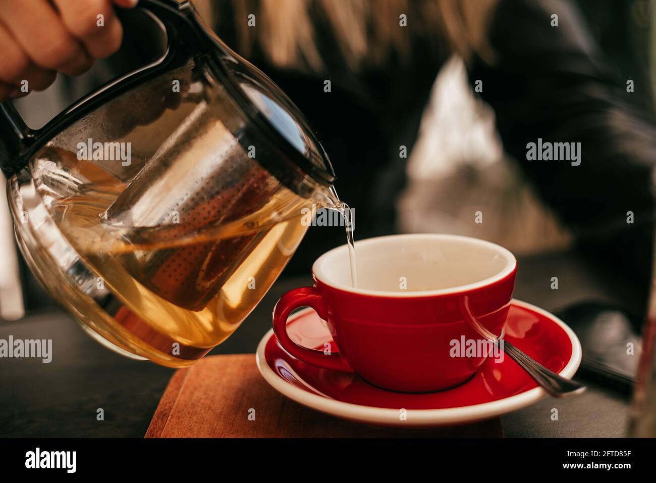 Close-up photo of woman's hand pouring tea from teapot into a cup Stock ...