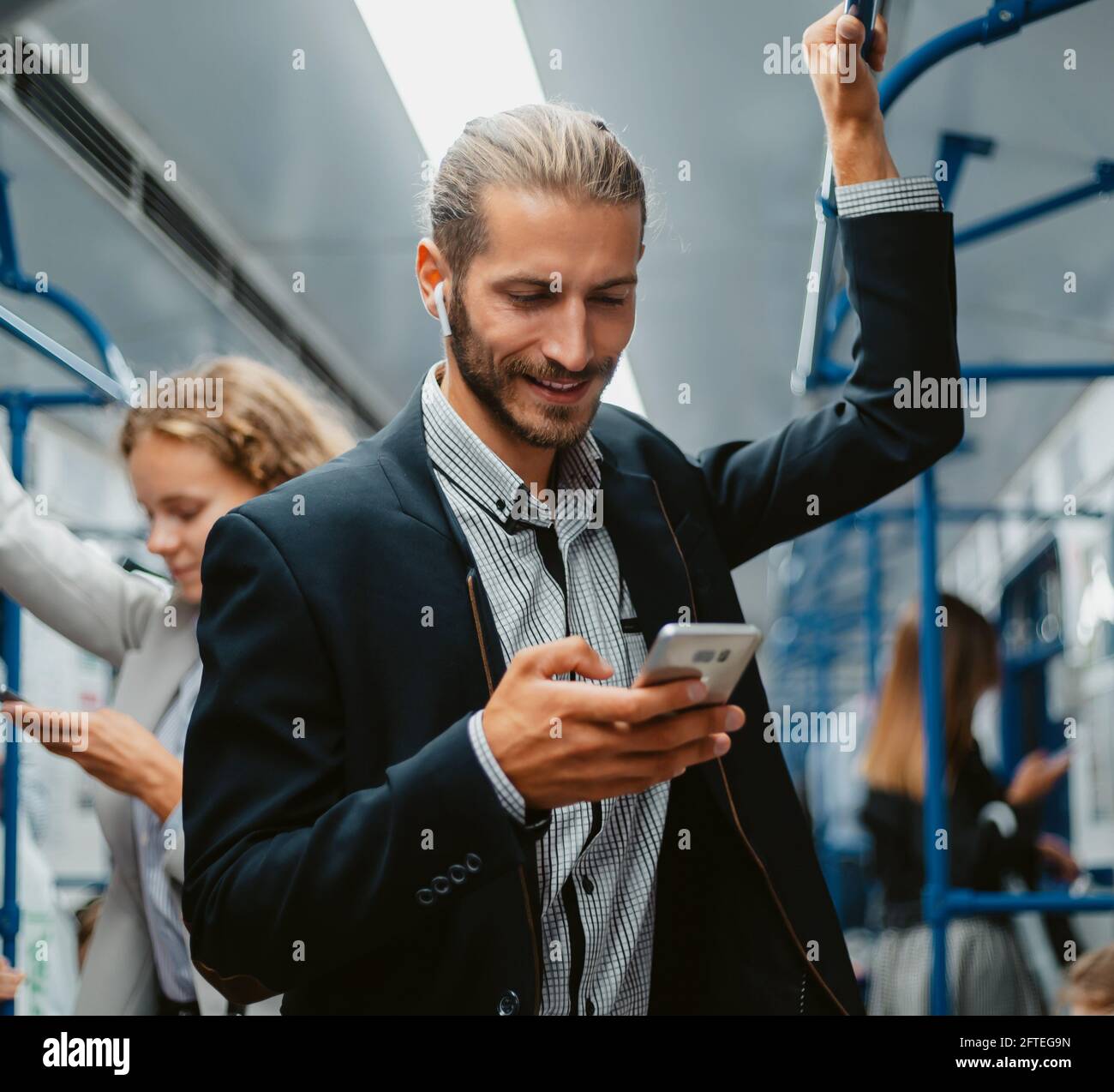 smiling passenger reading a message on his smartphone Stock Photo - Alamy
