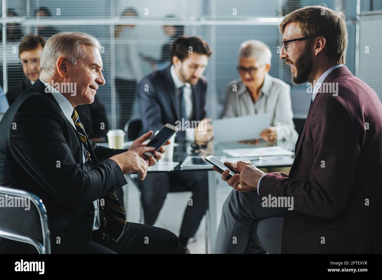 business colleagues using their smartphones during a work meeting Stock ...