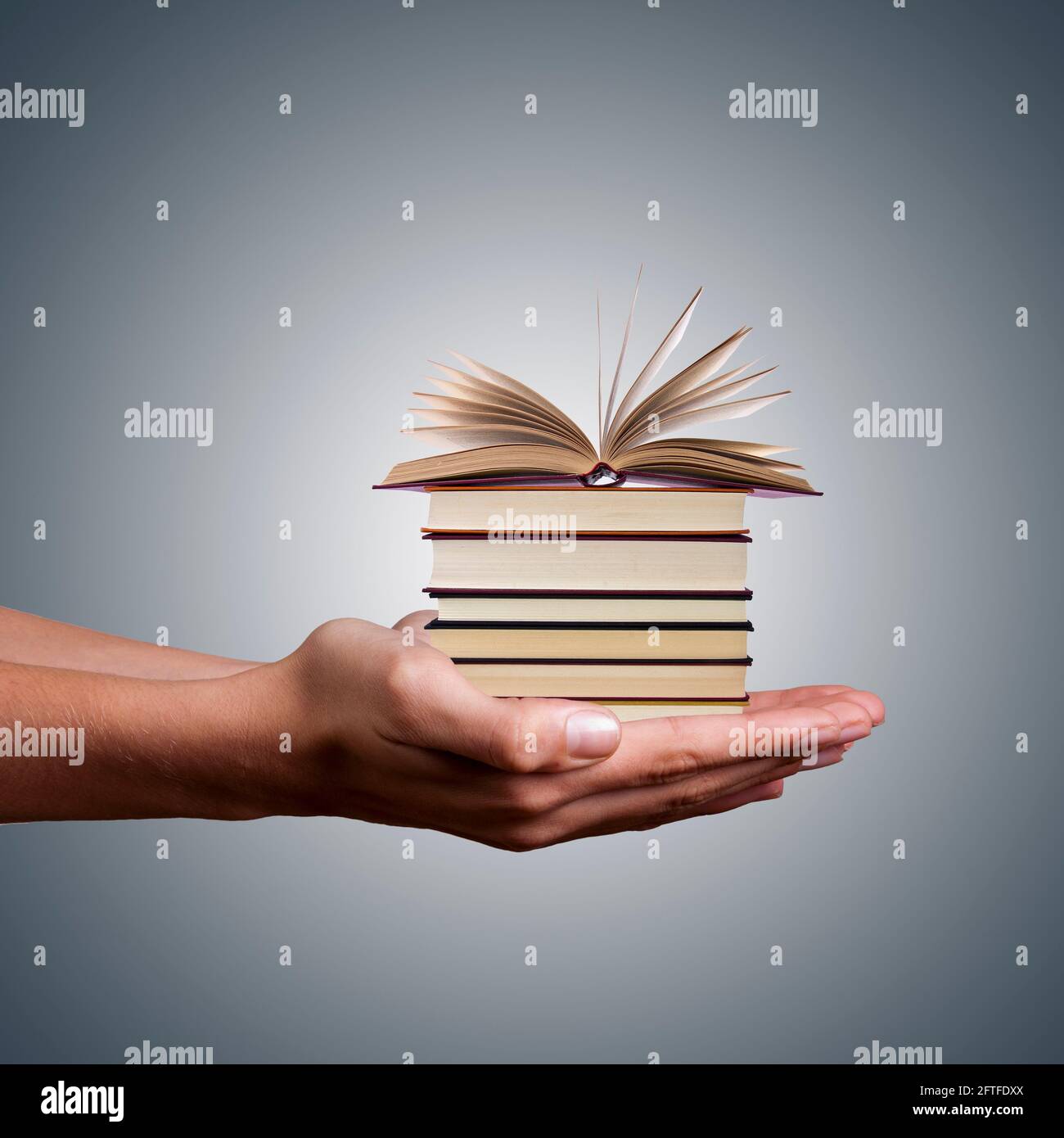 hands holding stacked books on white background Stock Photo - Alamy
