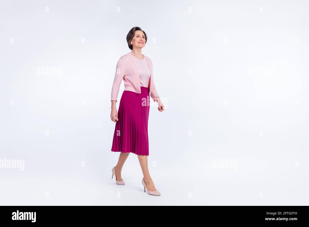 Photo of adorable shiny mature lady wear pink clothes smiling walking ...