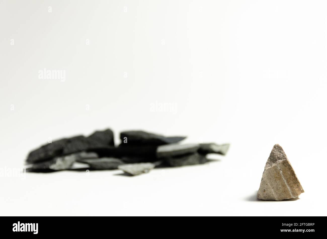 An isolated rock stands alone in front of a group of different looking ...