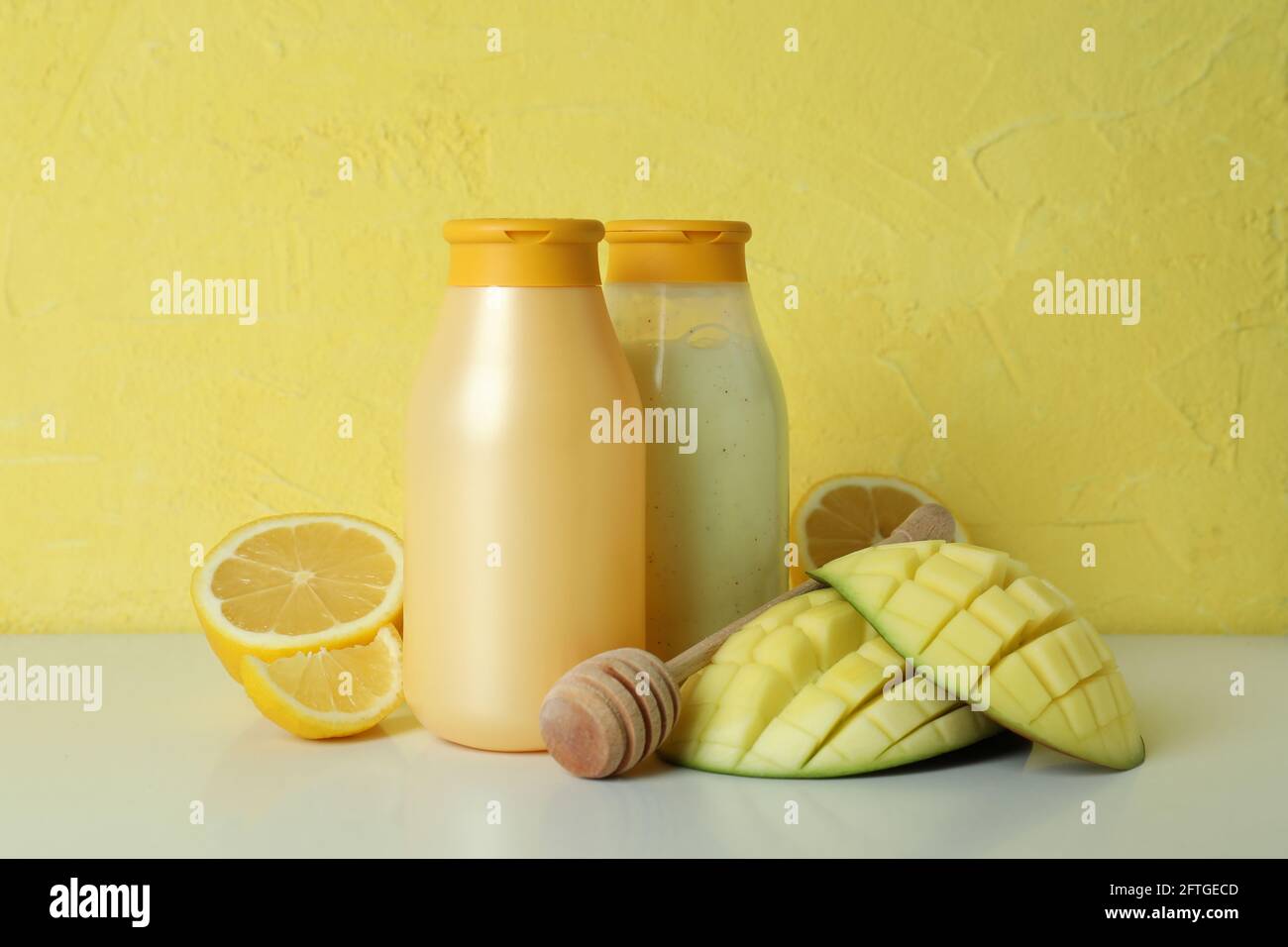 Shower gels, mango and lemon against yellow background Stock Photo - Alamy