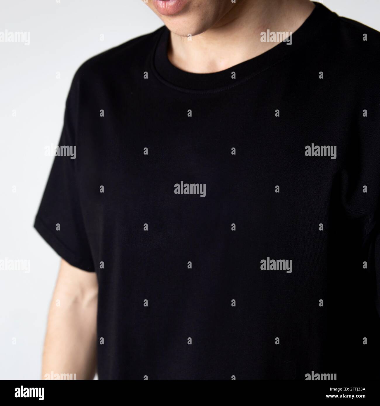 guy in a black basic T-shirt on a white background Stock Photo - Alamy