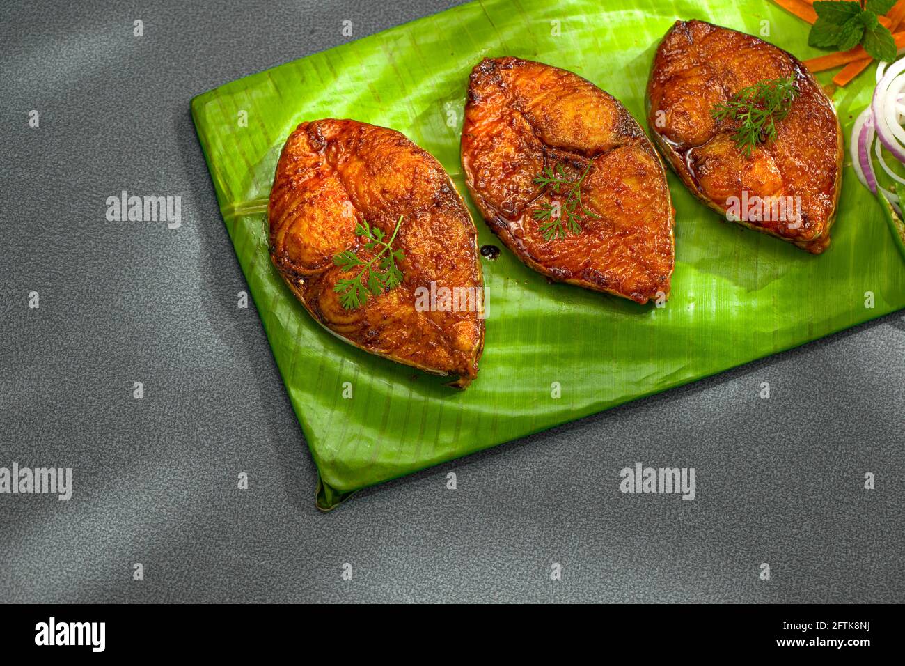 Seer fish fry arranged beautifully and garnished with onion, lemon and ...