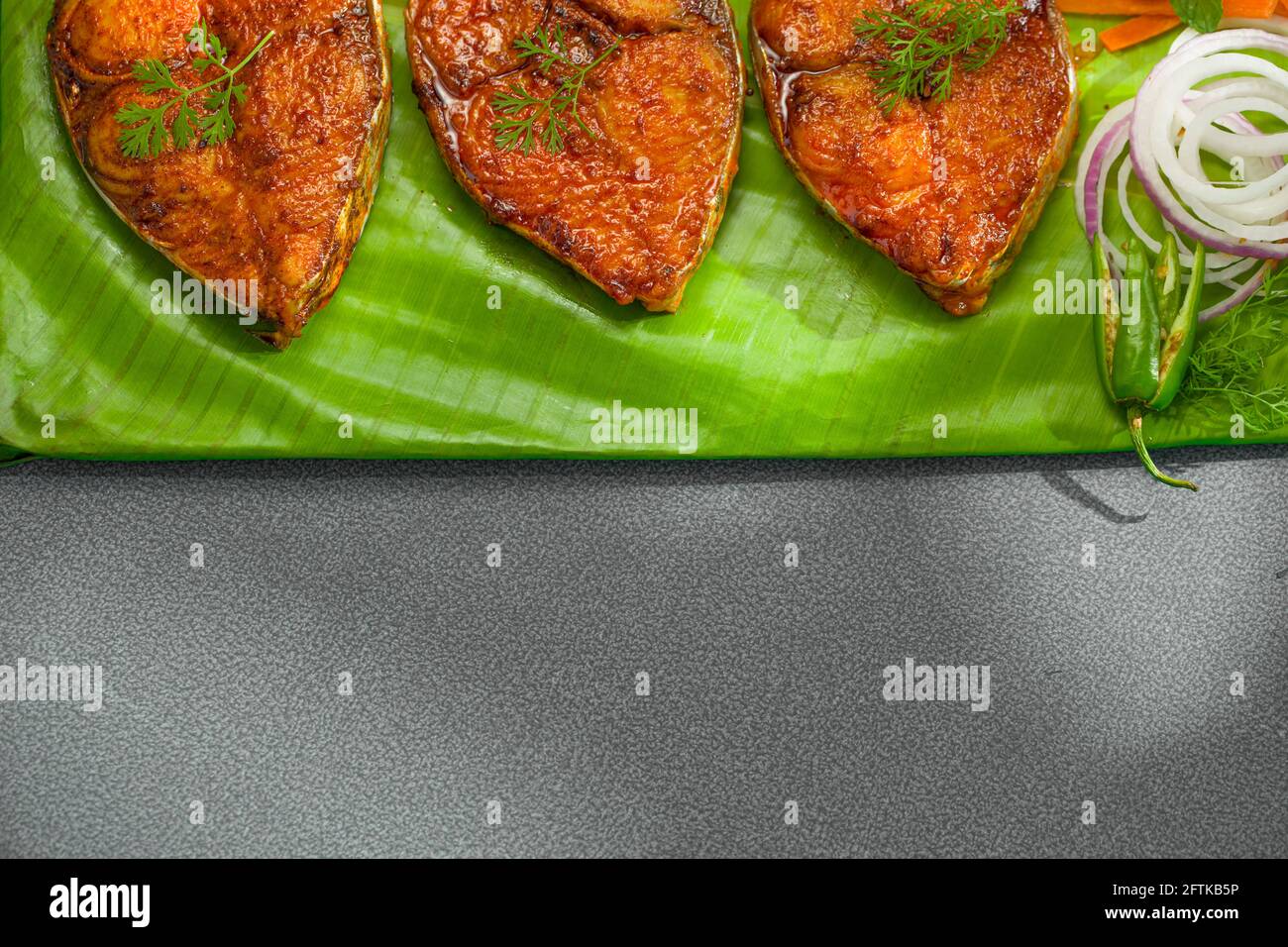 Seer fish fry arranged beautifully and garnished with onion, lemon and ...