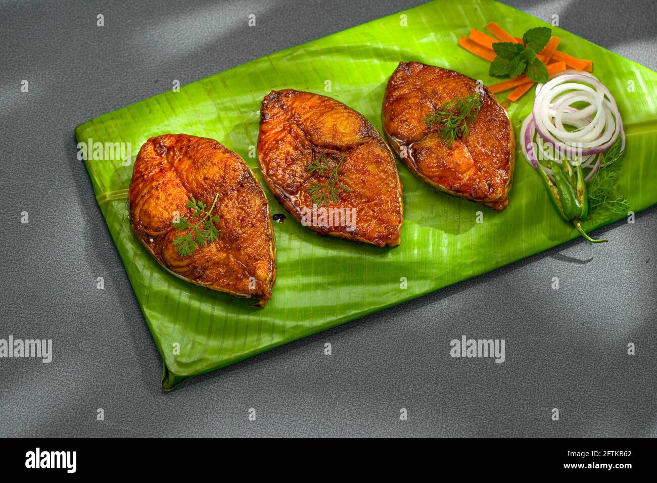 Seer fish fry arranged beautifully and garnished with onion, lemon and ...