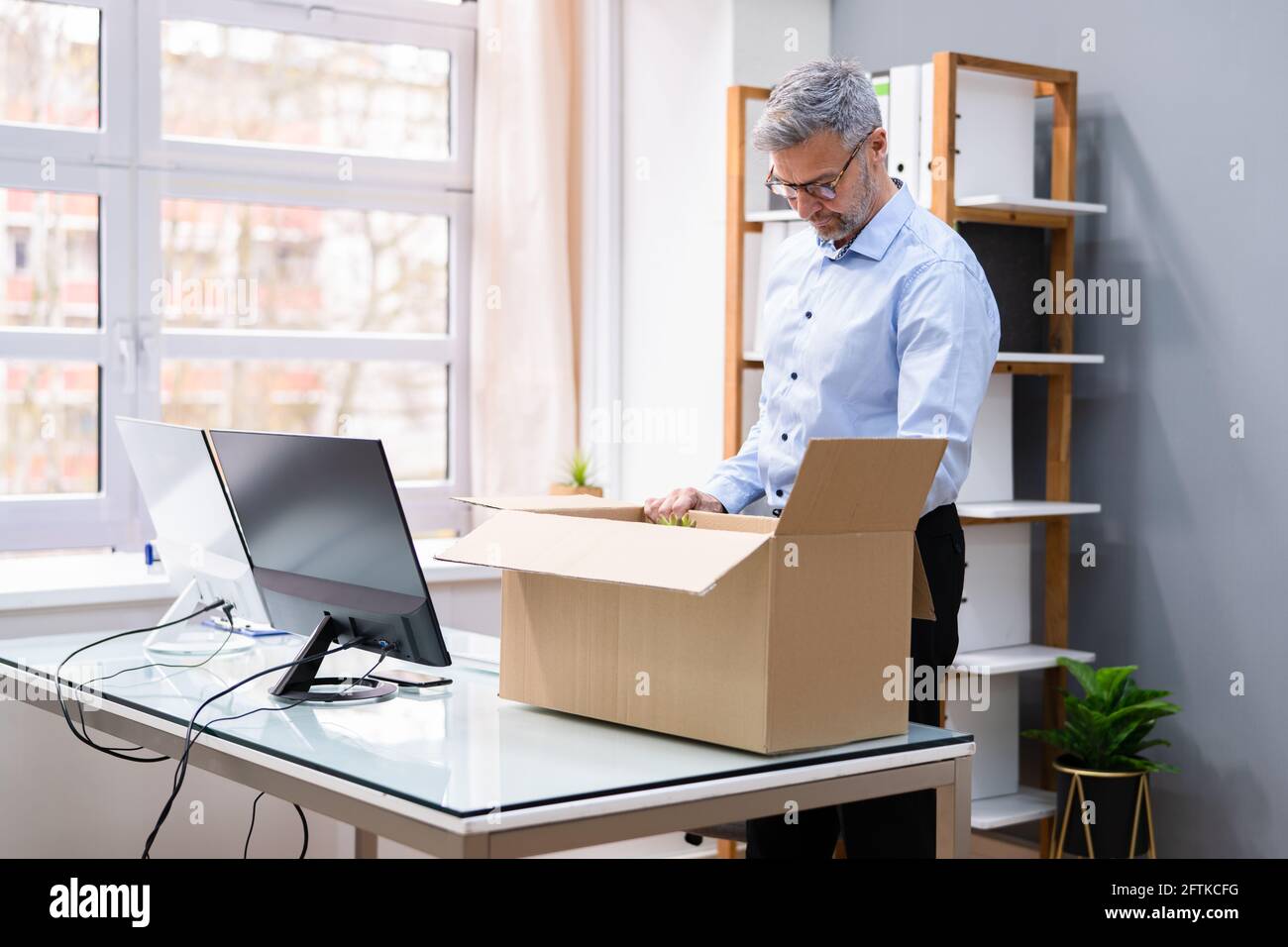 Job Quit. Employee Packing Cardboard Box At Desk Stock Photo - Alamy