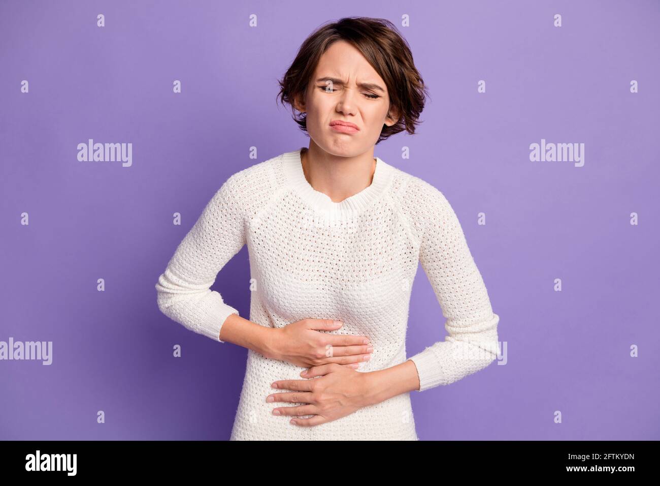 Portrait of attractive lady suffering stomach ache hands on belly ...