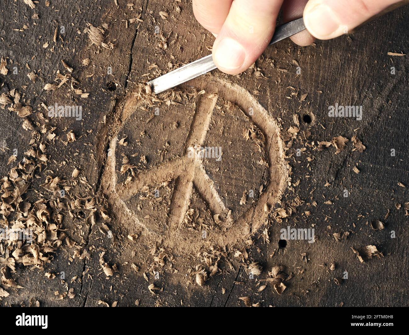 The peace symbol carved in wood with chisels. Peace concept, global ...