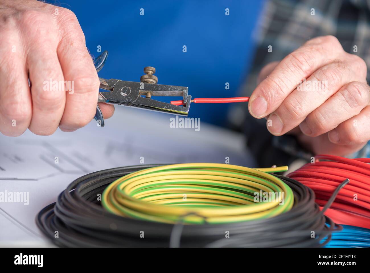 Electrician hands stripping a wire Stock Photo - Alamy