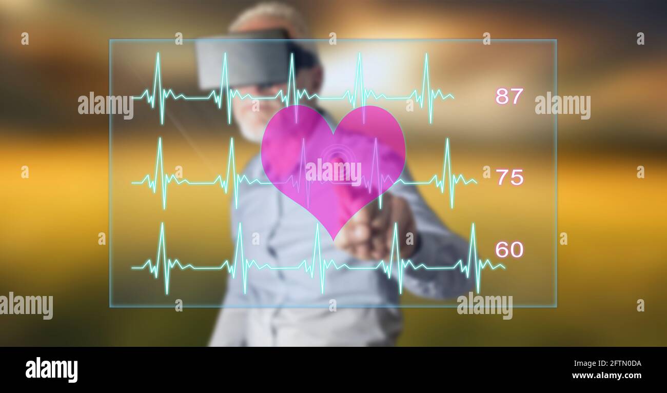 Man wearing a reality virtual headset touching a heart beats graph ...
