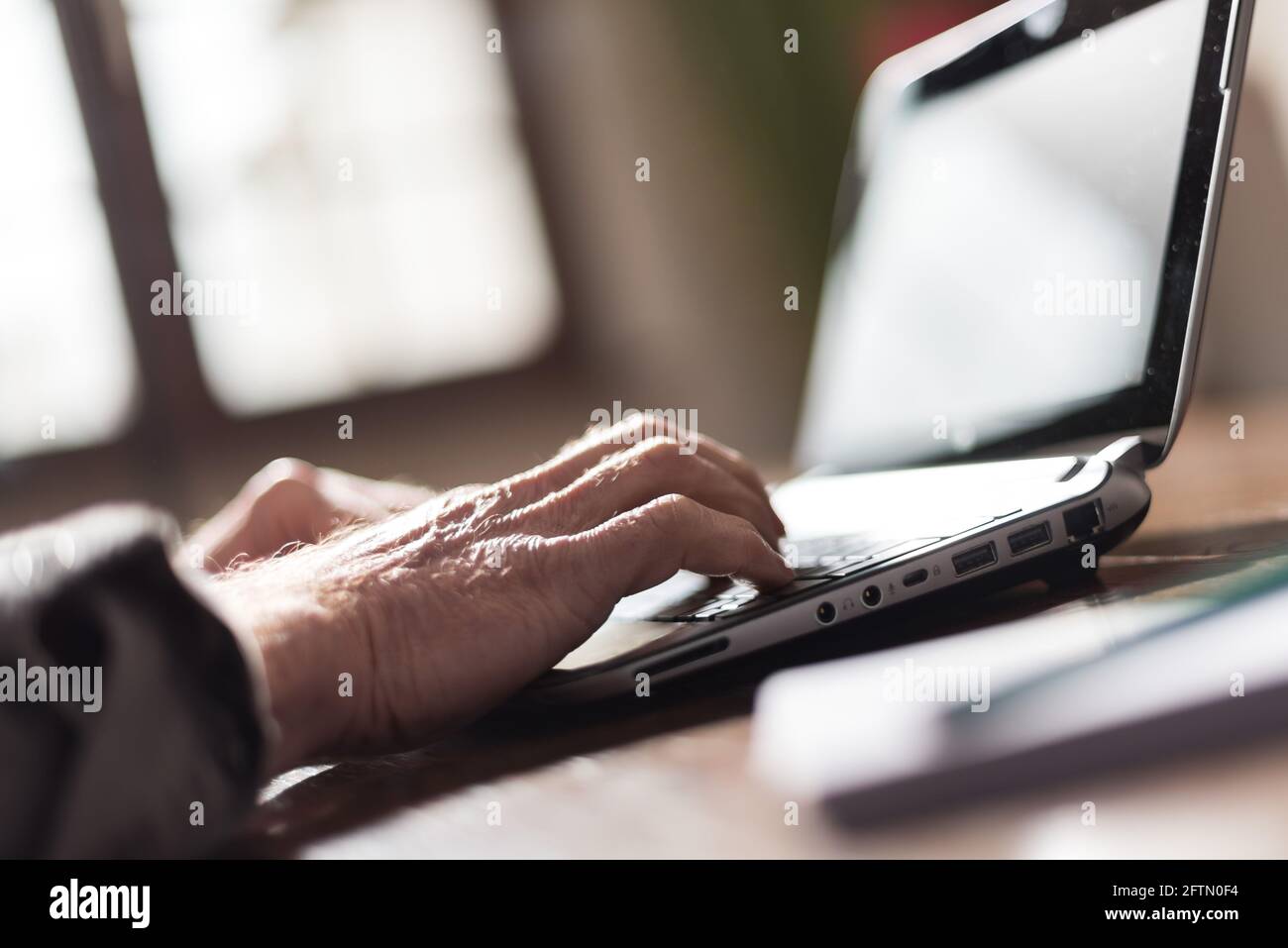 Hands using a laptop, closeup, hard light effect Stock Photo - Alamy