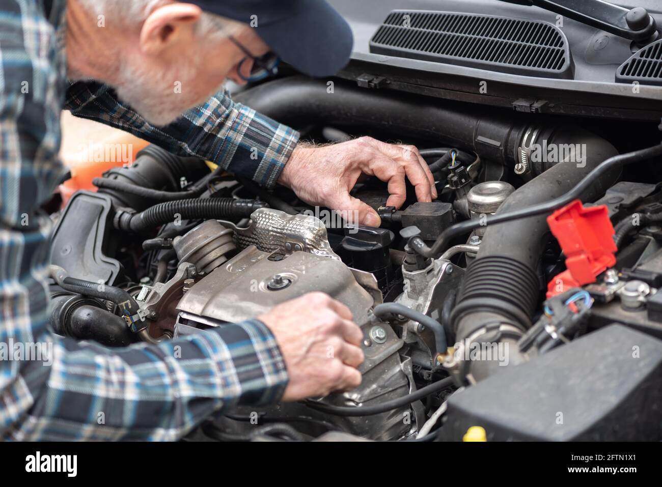 Car mechanic checking a car engine Stock Photo - Alamy