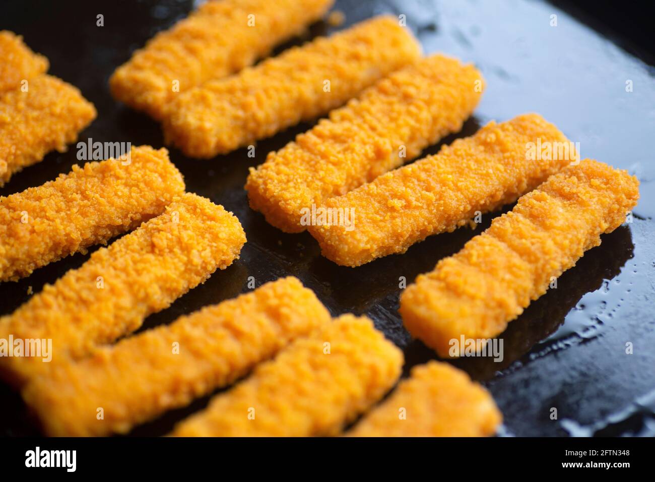 Fish sticks background. Fried fish sticks on a culinary baking sheet as ...