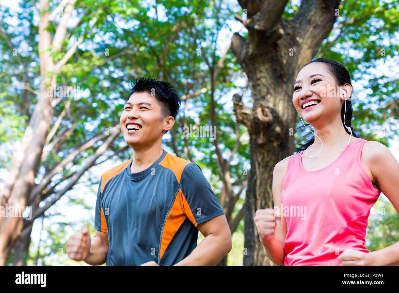 Asian Chinese man and woman jogging in city park Stock Photo - Alamy