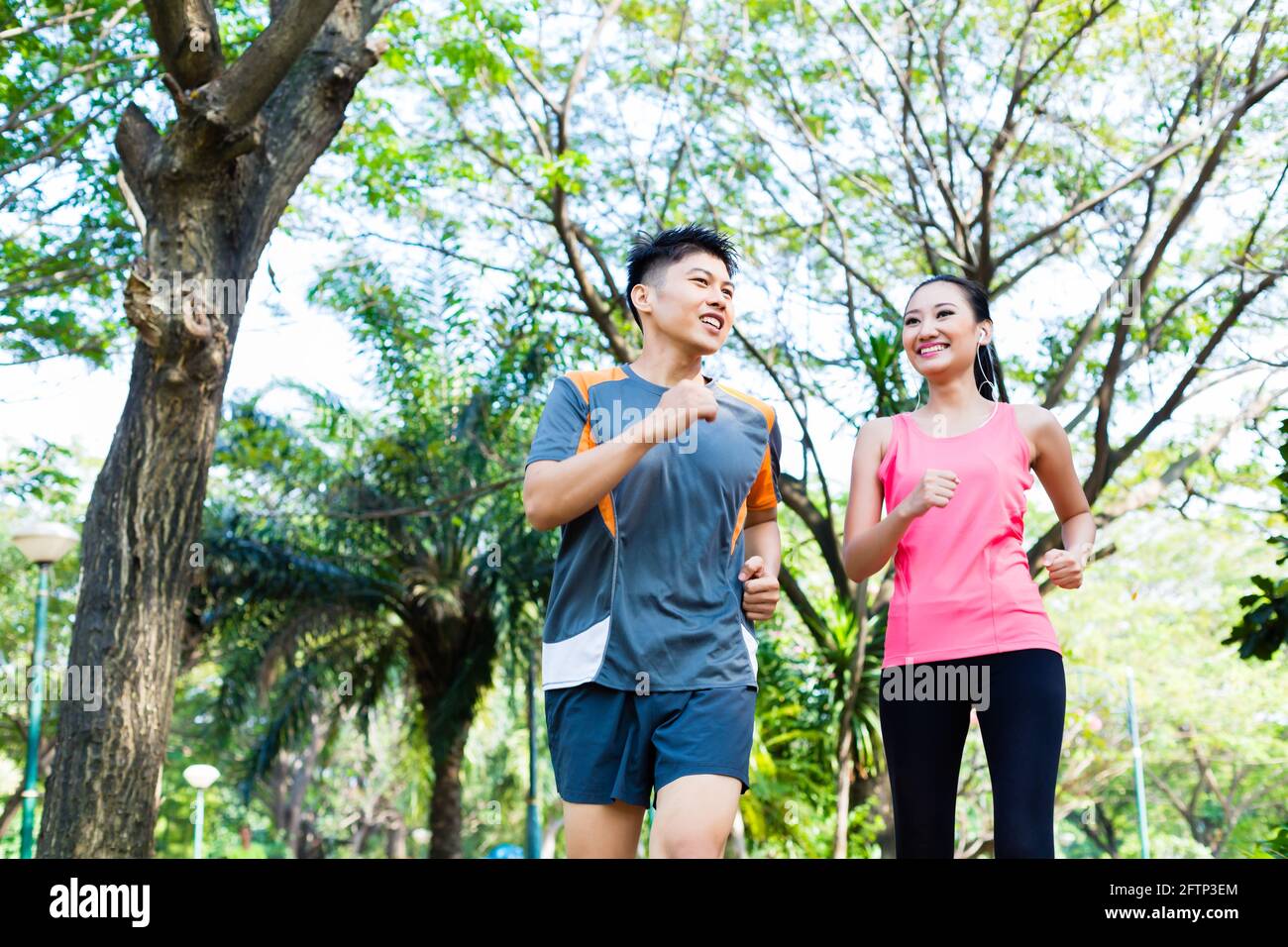 Asian Chinese man and woman jogging in city park Stock Photo - Alamy