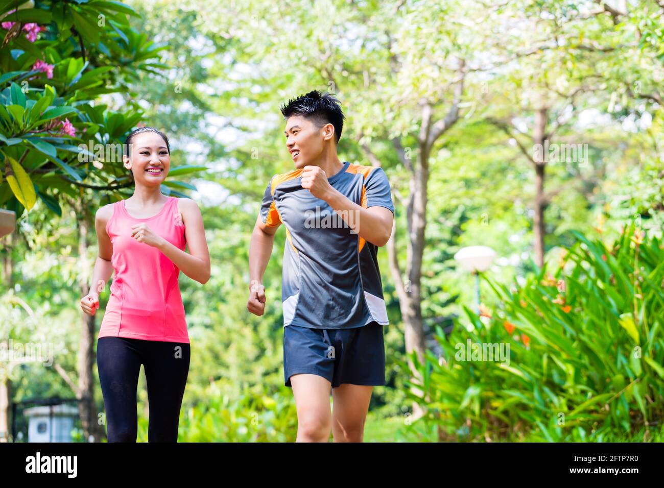 Asian Chinese man and woman jogging in city park Stock Photo - Alamy