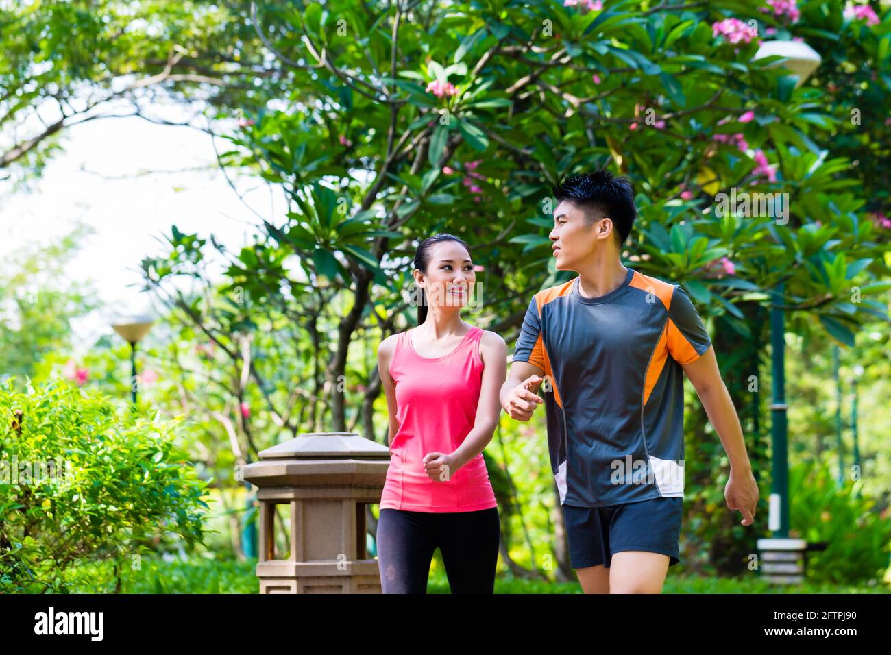 Asian Chinese man and woman jogging in city park Stock Photo - Alamy