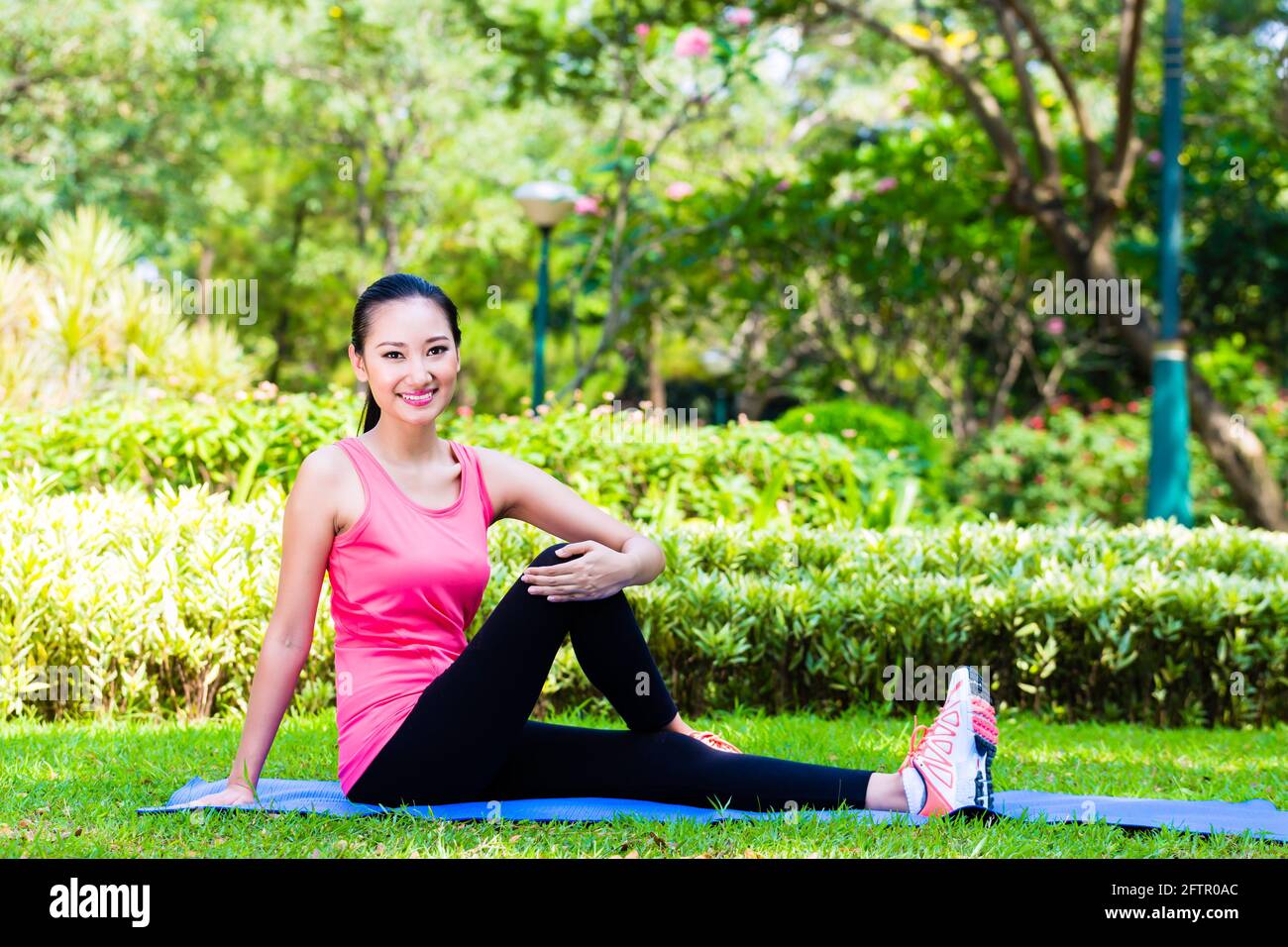Asian Chinese woman stretching muscles for fitness in city park Stock ...