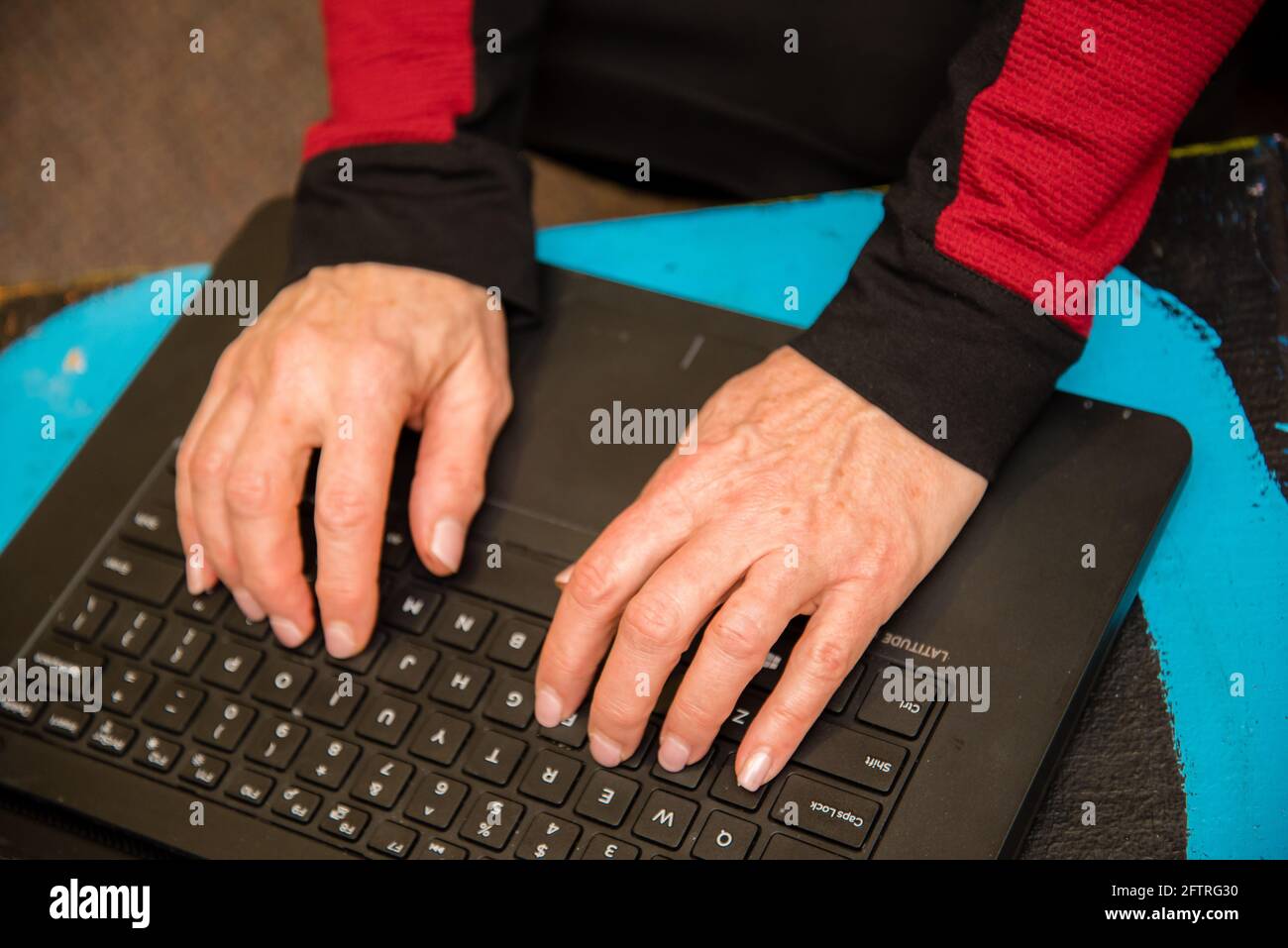 Overhead view of woman's hands typing on a black keyboard laptop Stock ...