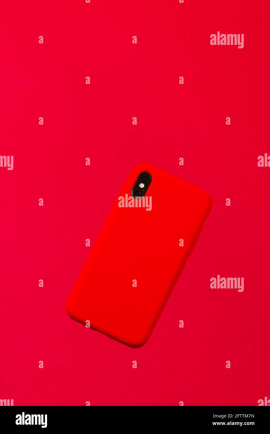 Red smartphone case against a red background Stock Photo - Alamy