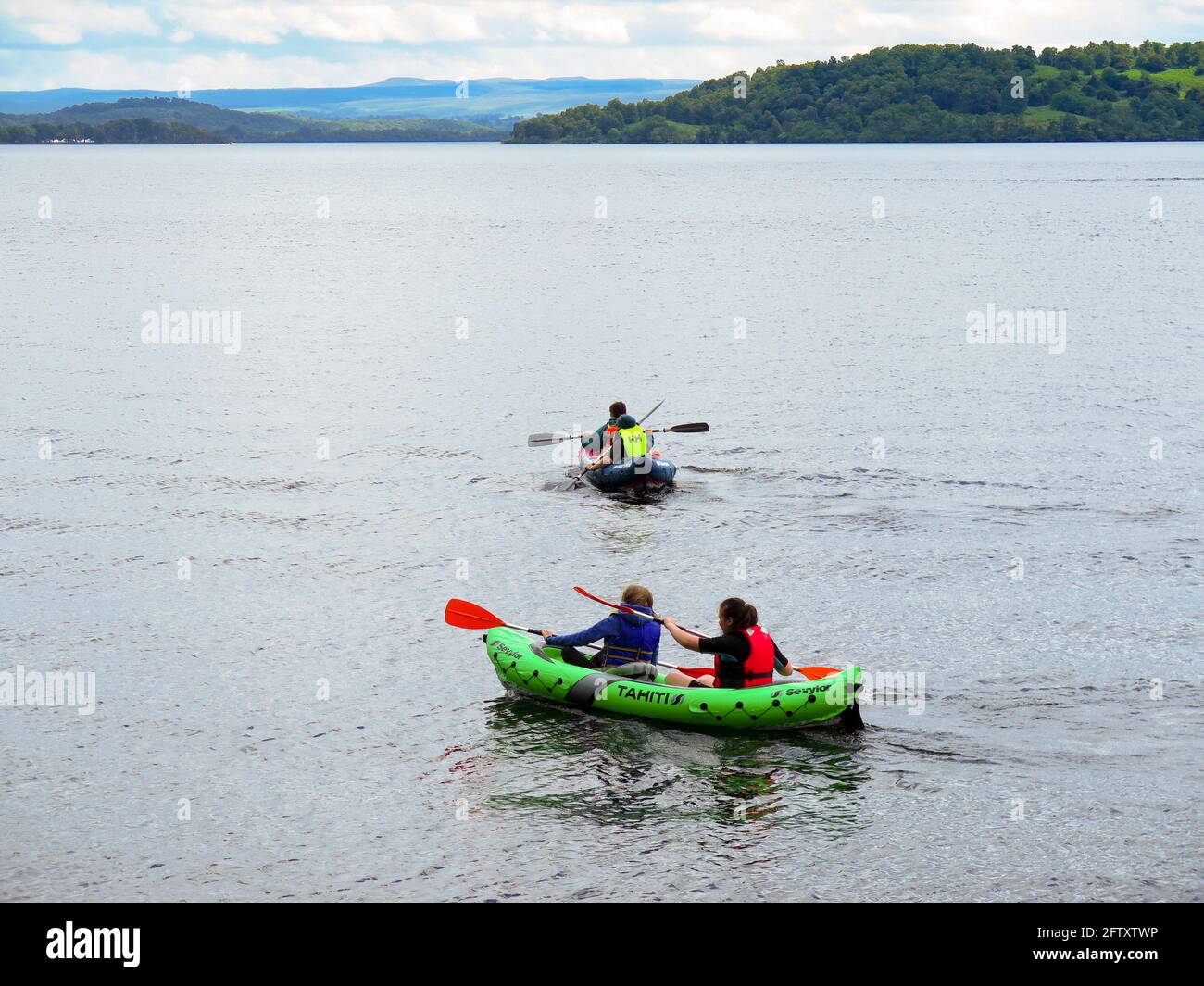 People in inflatable canoe on lake or loch Stock Photo - Alamy