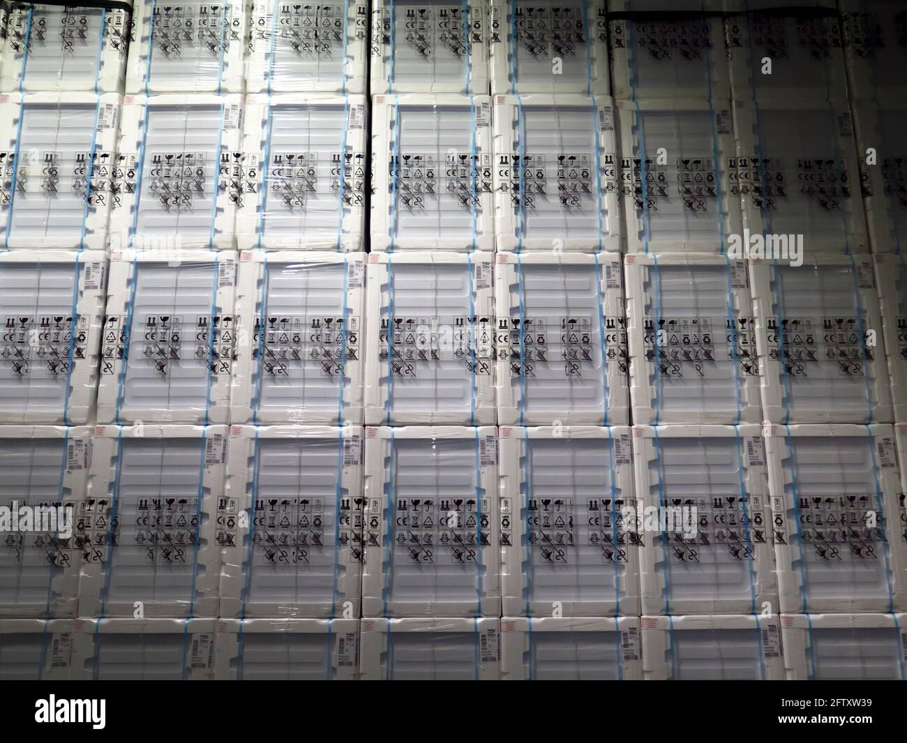 Large stack of packaged white goods in warehouse Stock Photo - Alamy