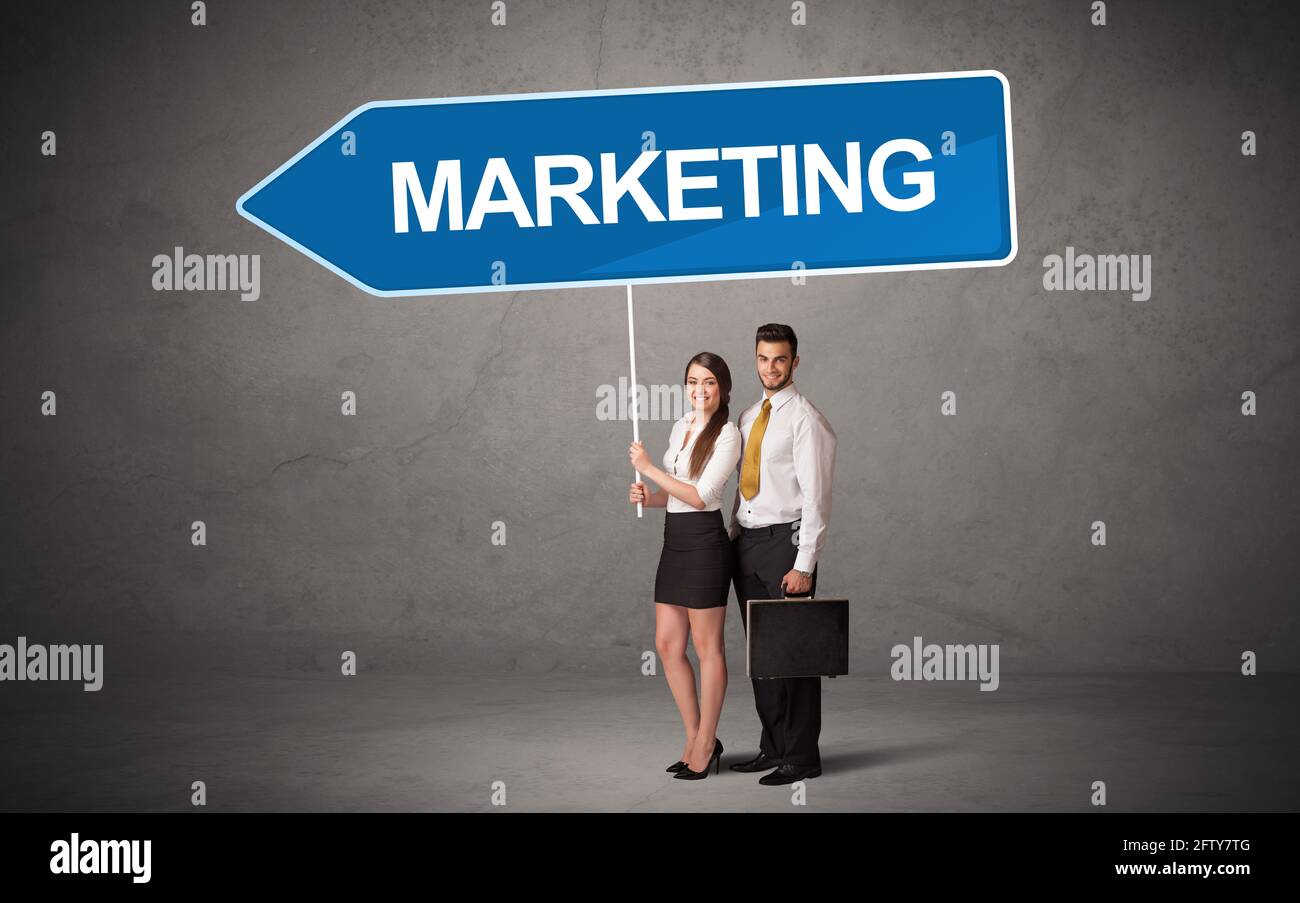 Young business person in casual holding road sign Stock Photo - Alamy