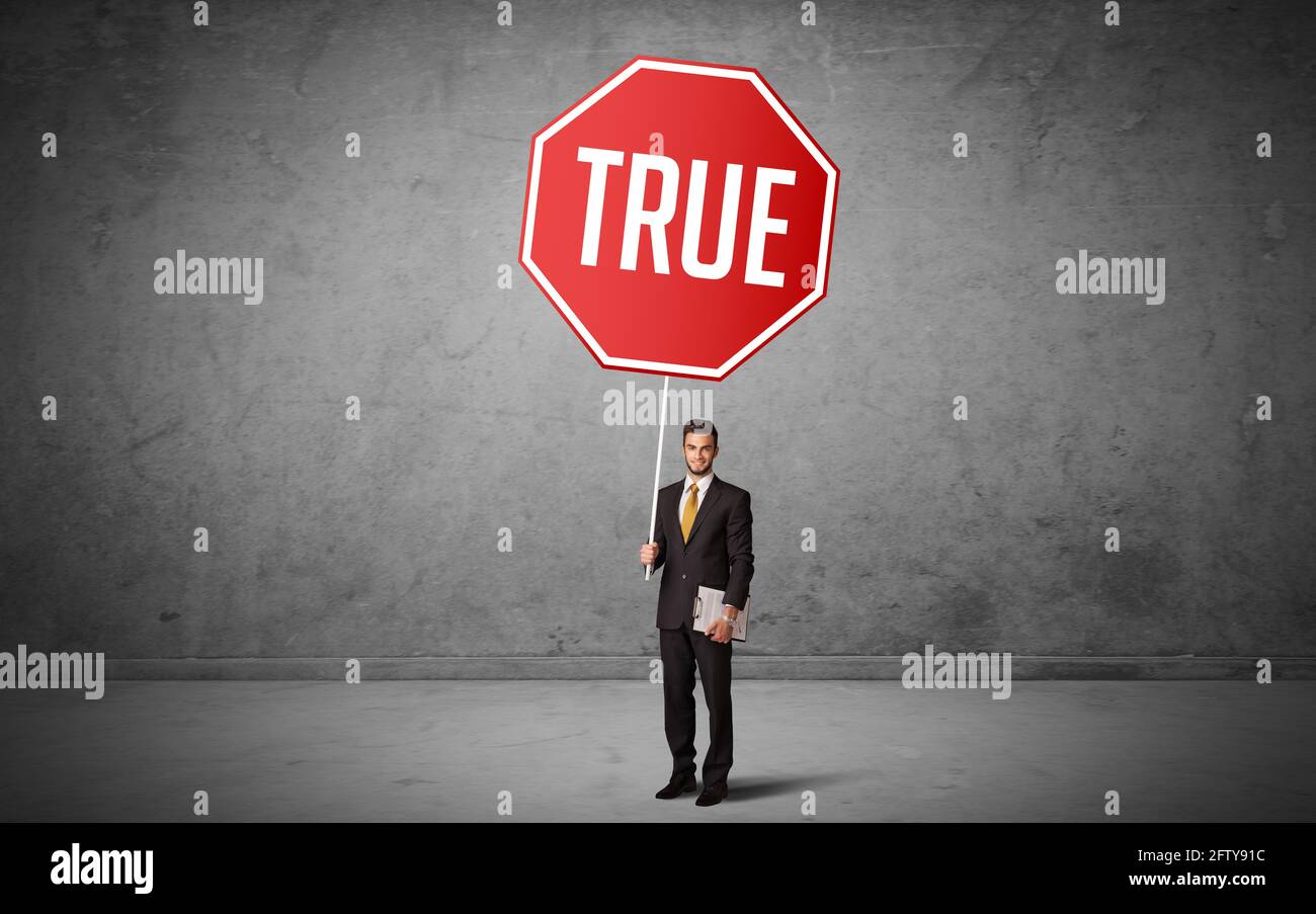 Young business person holding road sign Stock Photo - Alamy