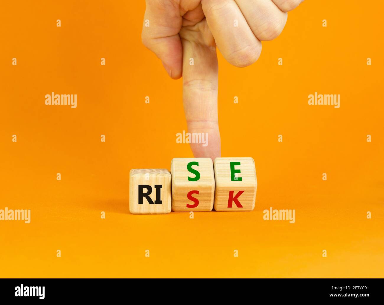 Risk vs rise symbol. Businessman turns wooden cubes and changes the ...