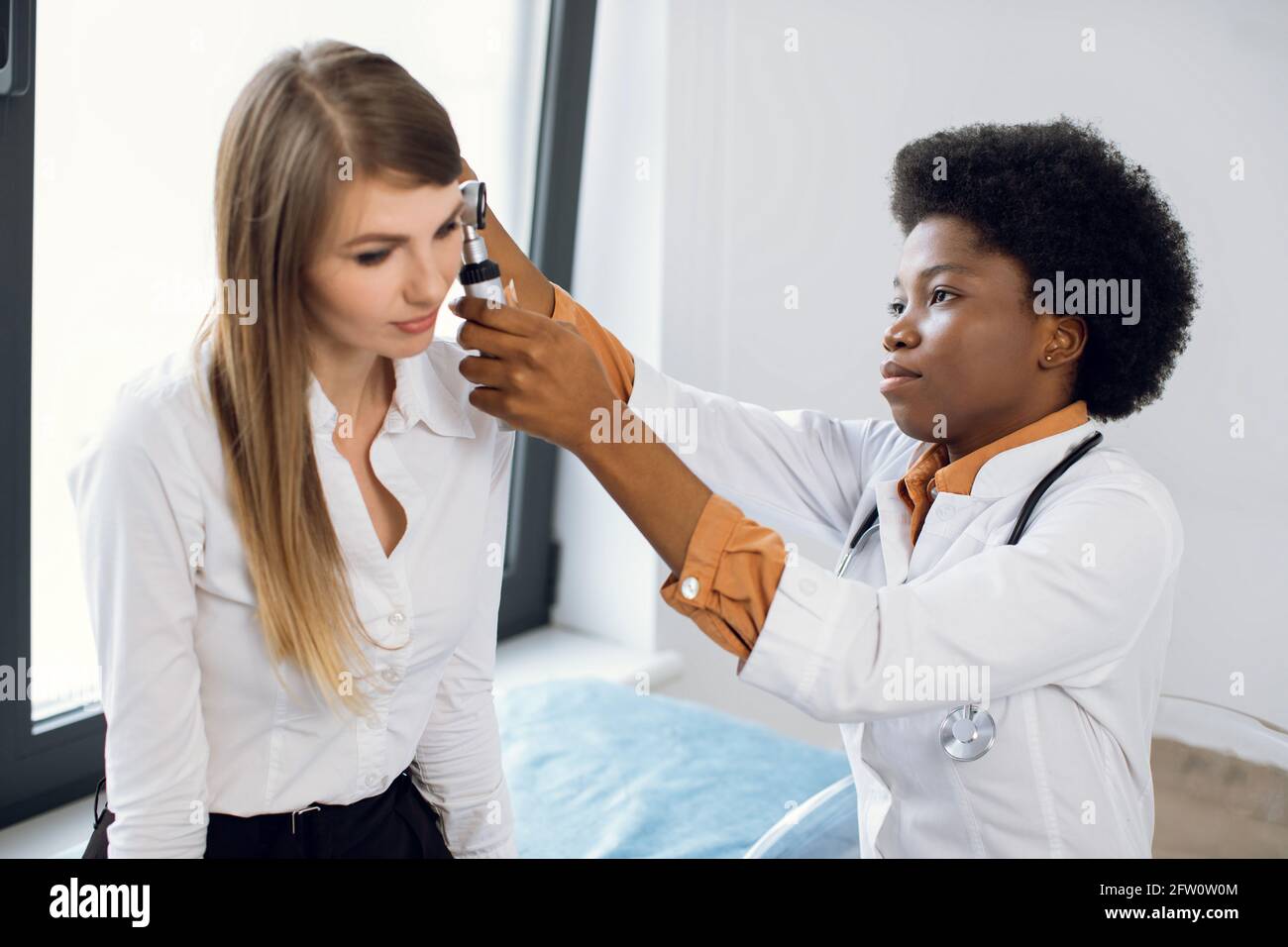 ENT doctor and patient in modern hospital. Female confident African ...
