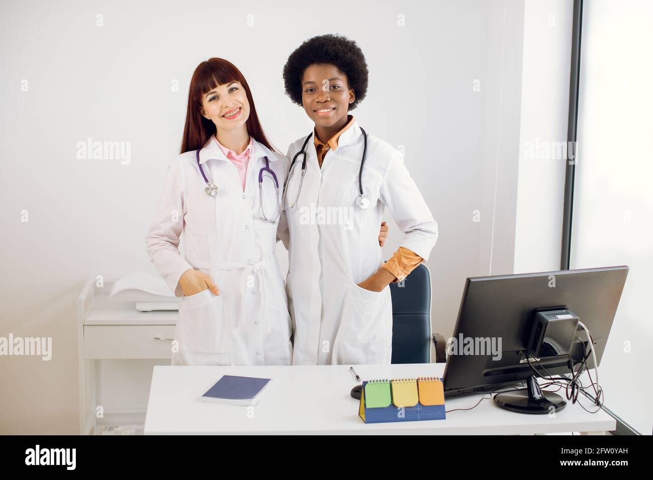 Pretty two young multiethnical women doctors, African and Caucasian ...