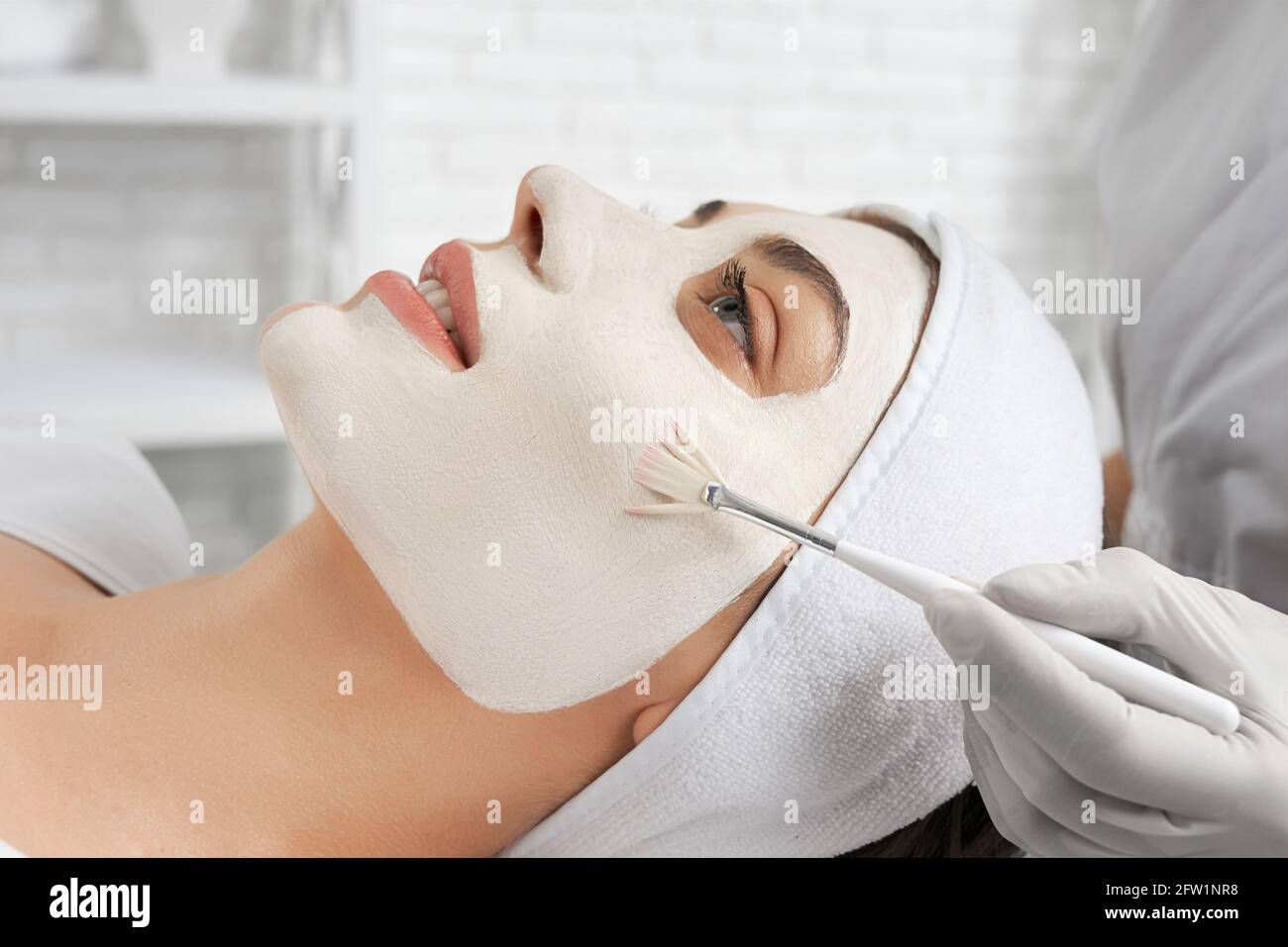 Side view portrait of beautician hands in rubber gloves holding brush ...