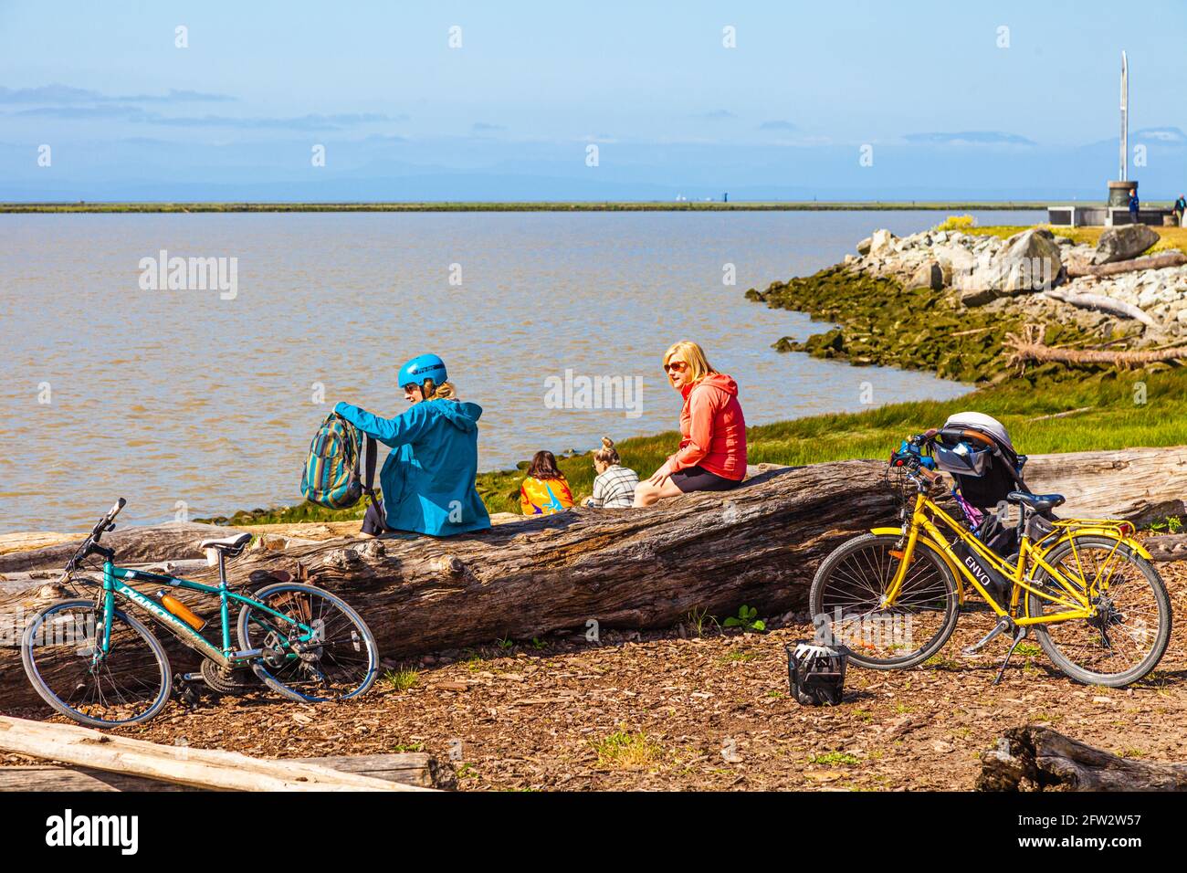 Two cycling friends sitting on a driftwood log at Gary Point Park in ...