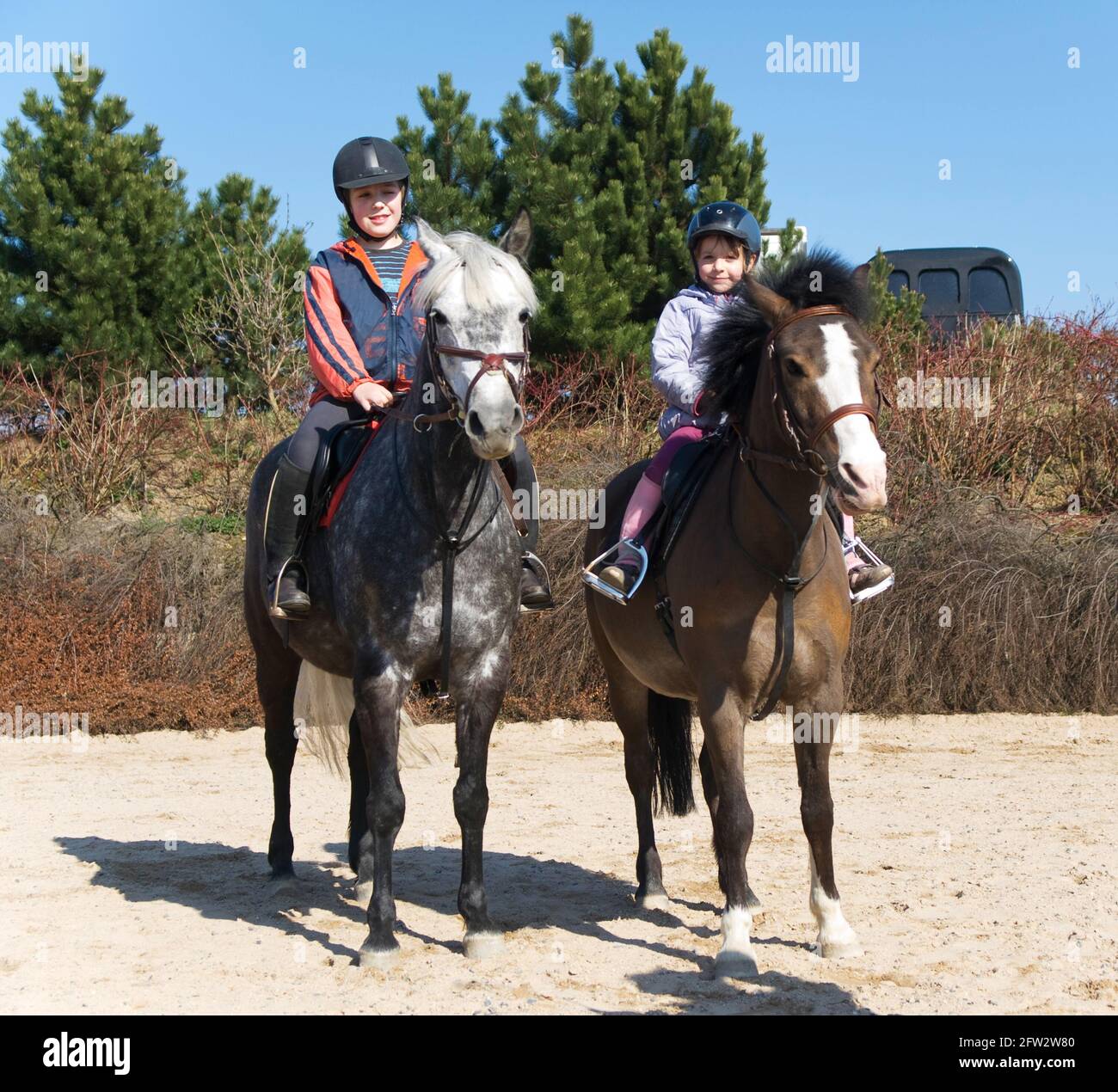 Couple of children riding horses Stock Photo - Alamy