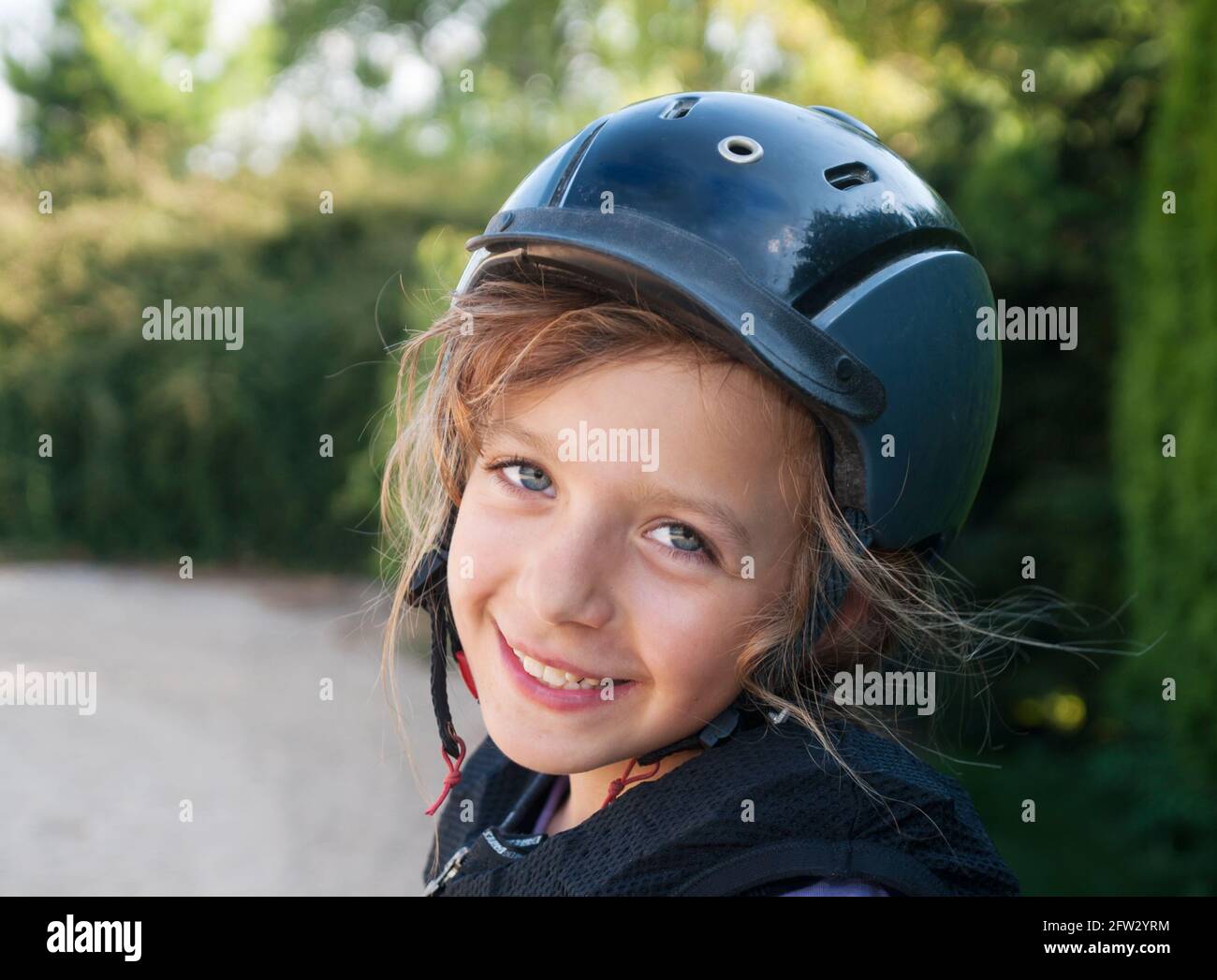 Happy little girl in helmet for horseriding Stock Photo - Alamy