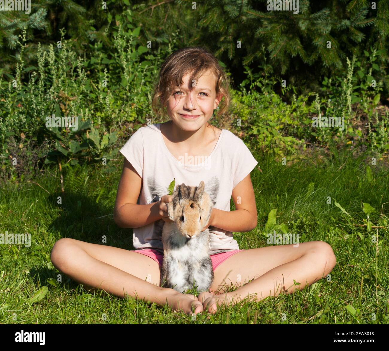 Girl playing with rabbit pet Stock Photo - Alamy