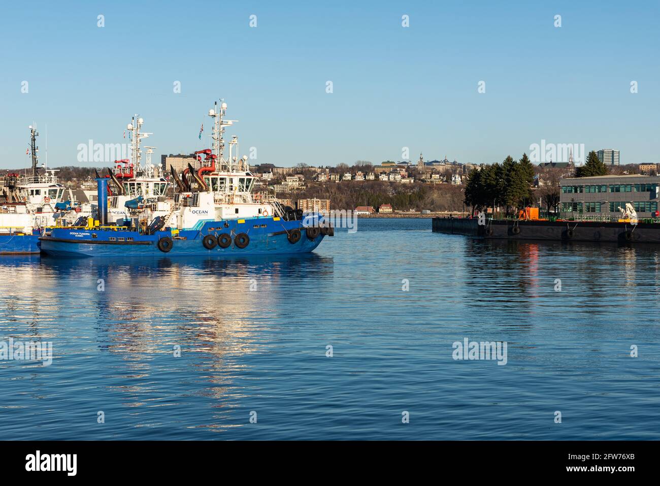 Tugs in the harbor of Quebec city with the Saint-Lawrence and Levis in ...