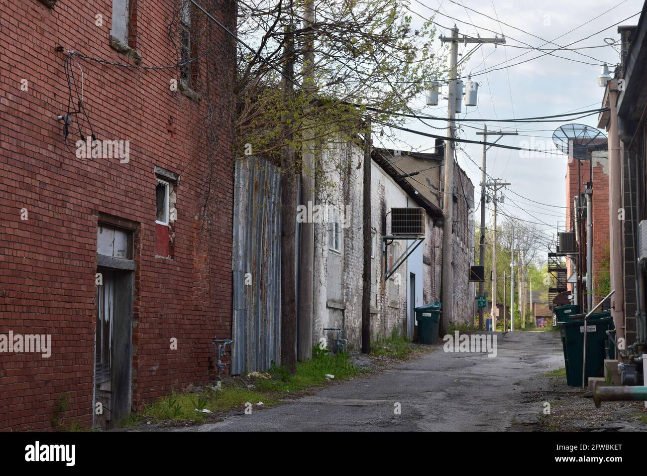 Old service alley behind businesses with infrastructure Stock Photo - Alamy