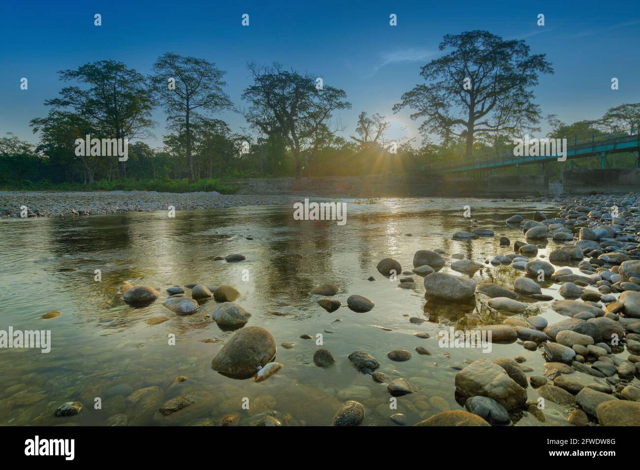 Beautiful sunrise over Murti river, riverbed in foreground with flowing ...