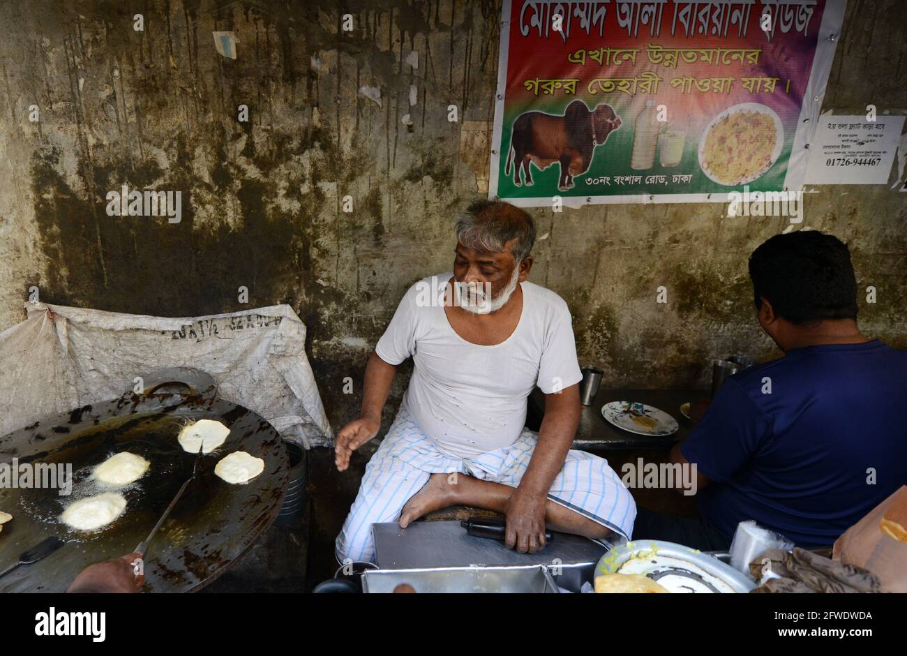 Frying roti bread in a small hole in the wall restuarant in old Dhaka ...