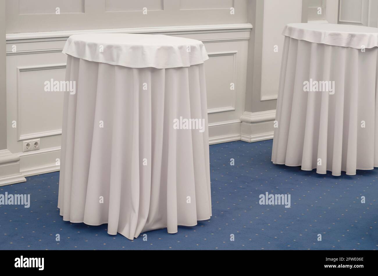 Buffet tables covered with white tablecloths in a beautiful interior ...