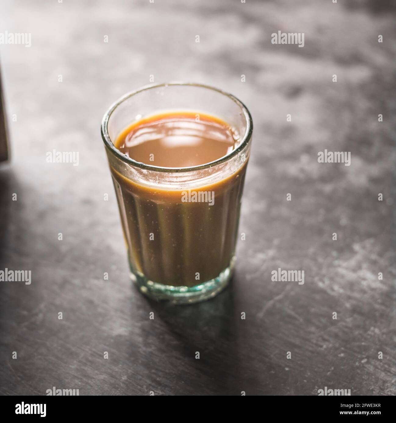 Indian chai in glass cups with metal kettle and other masalas to make ...